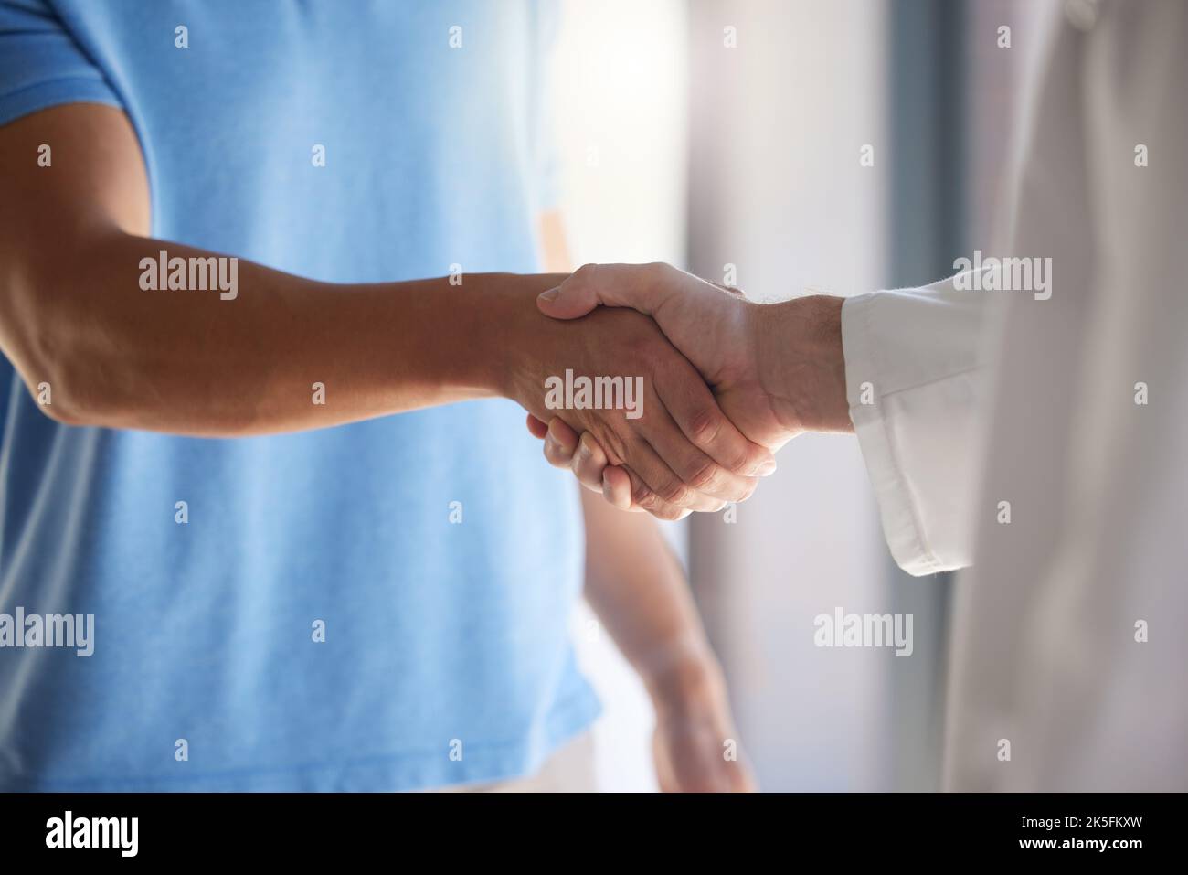 Handshake, trust and respect with a patient and medical worker or ...