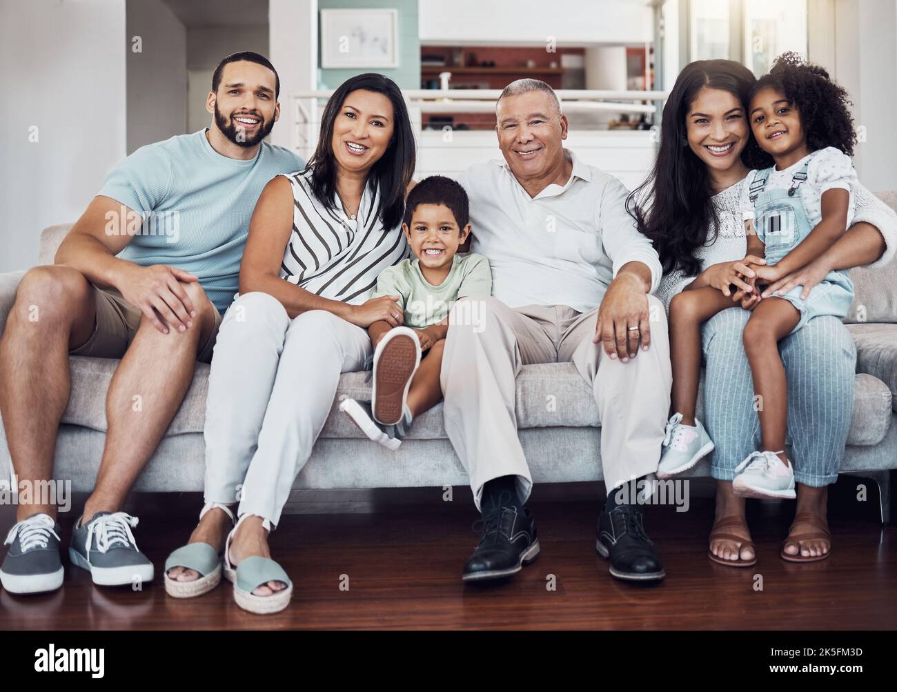 Portrait, family and on sofa with parents, grandparents and children happy and bonding at home ...