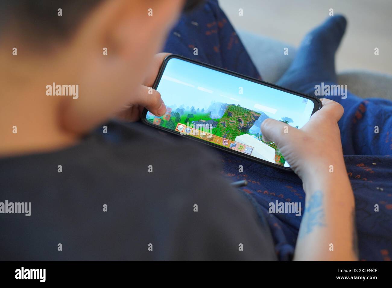 A young boy playing Minecraft on a smartphone Stock Photo - Alamy