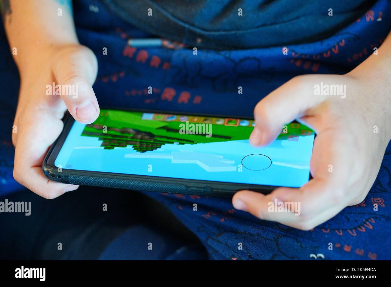 A young boy playing Minecraft on a smartphone Stock Photo - Alamy