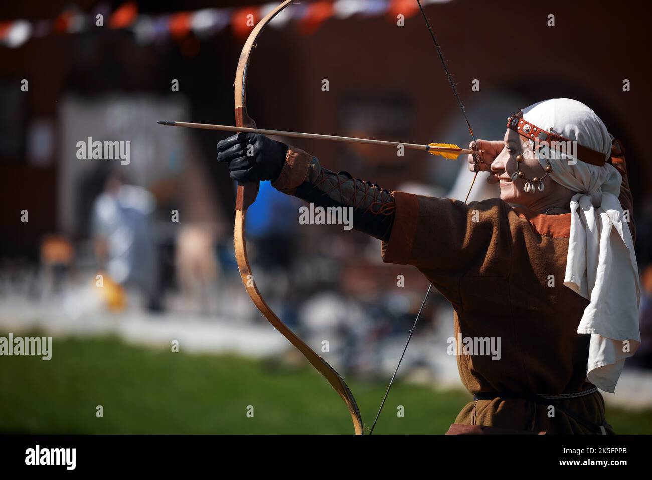 Medieval archery tournament. A woman shoots an arrow in the medieval ...