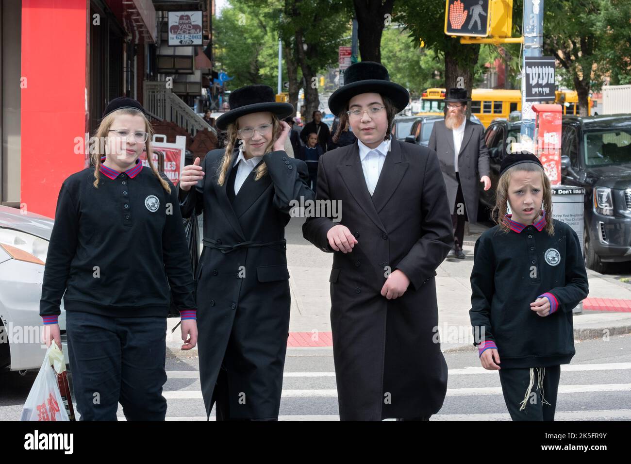 4 orthodox Jewish boys with long peyus walk on Lee Avenue in ...