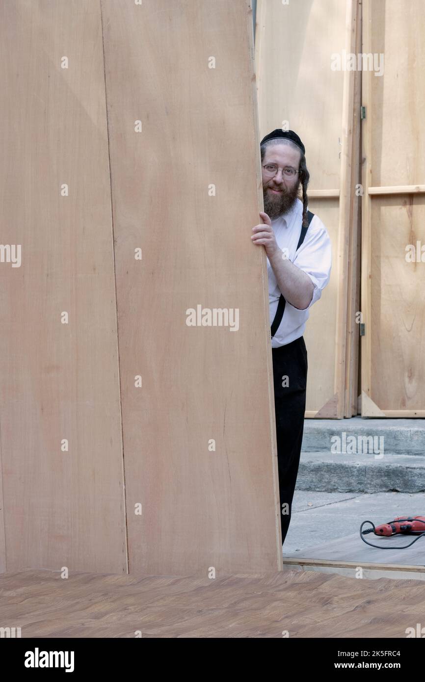 In preparation for the Sukkos holiday, an orthodox Jewish man builds a ...