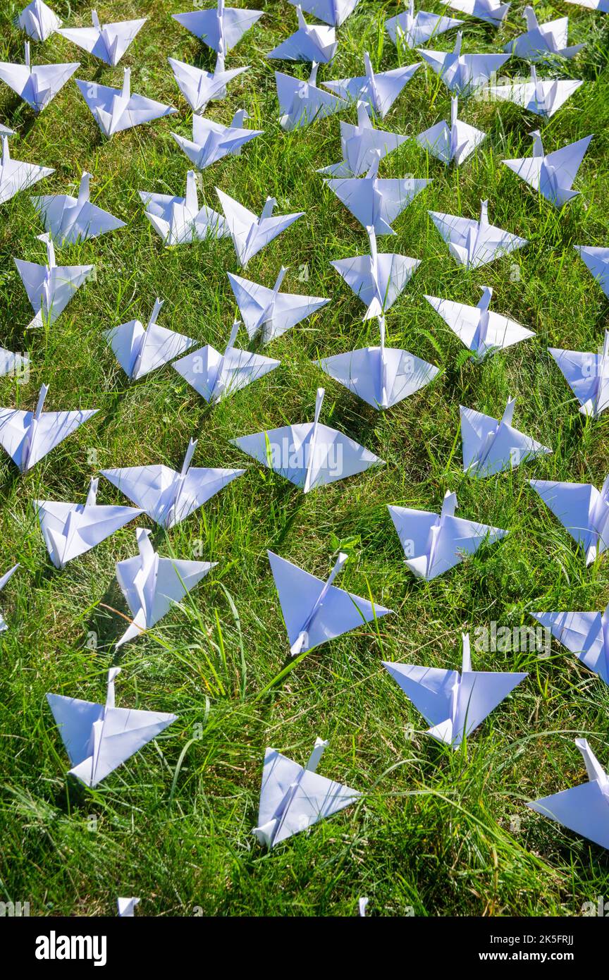 Japanese folded Origami cranes on fresh grass. Hundreds handmade paper ...