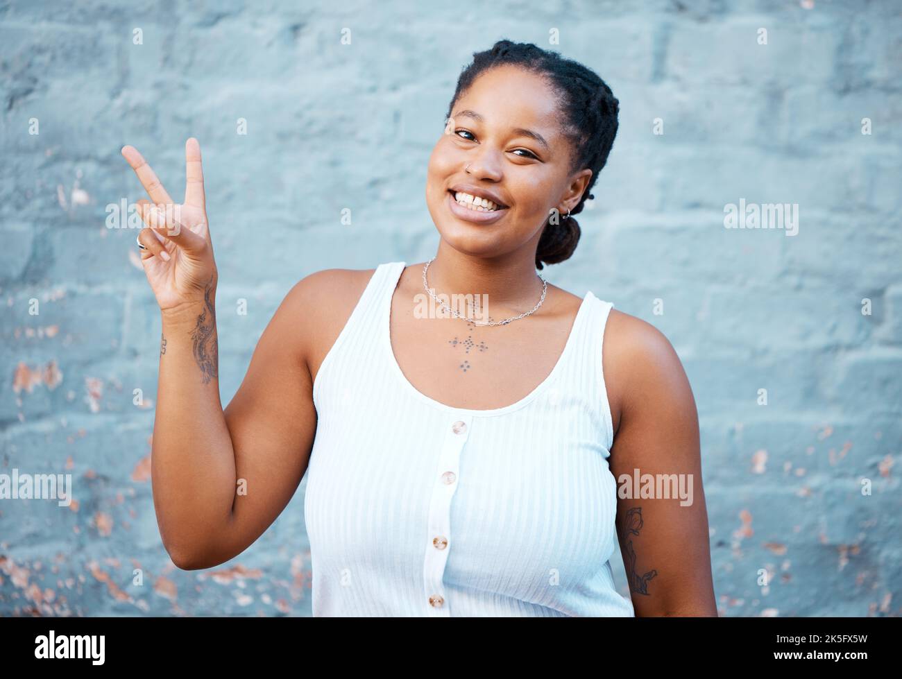 Portrait, peace sign and happy black woman with wall background smiling ...