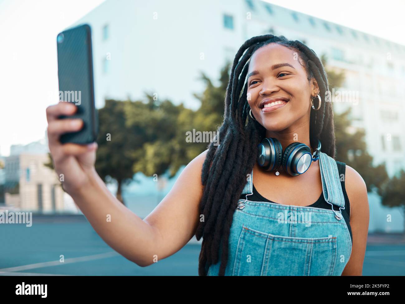 Happy young black woman in city, selfie video call on smartphone and ...