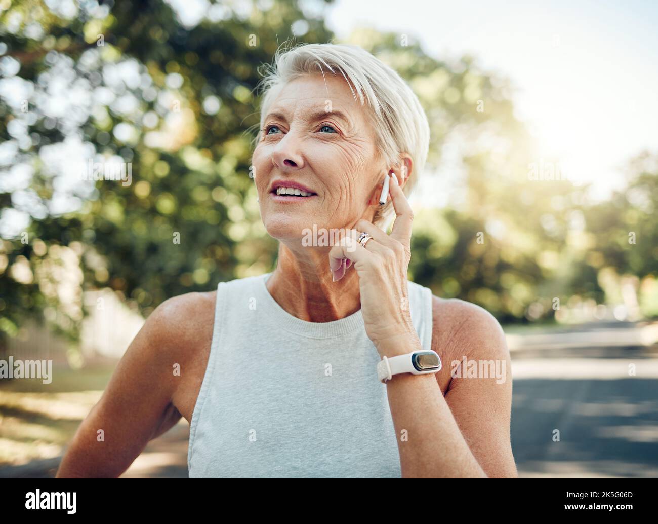 Senior woman, fitness and music earphones for workout, training or ...