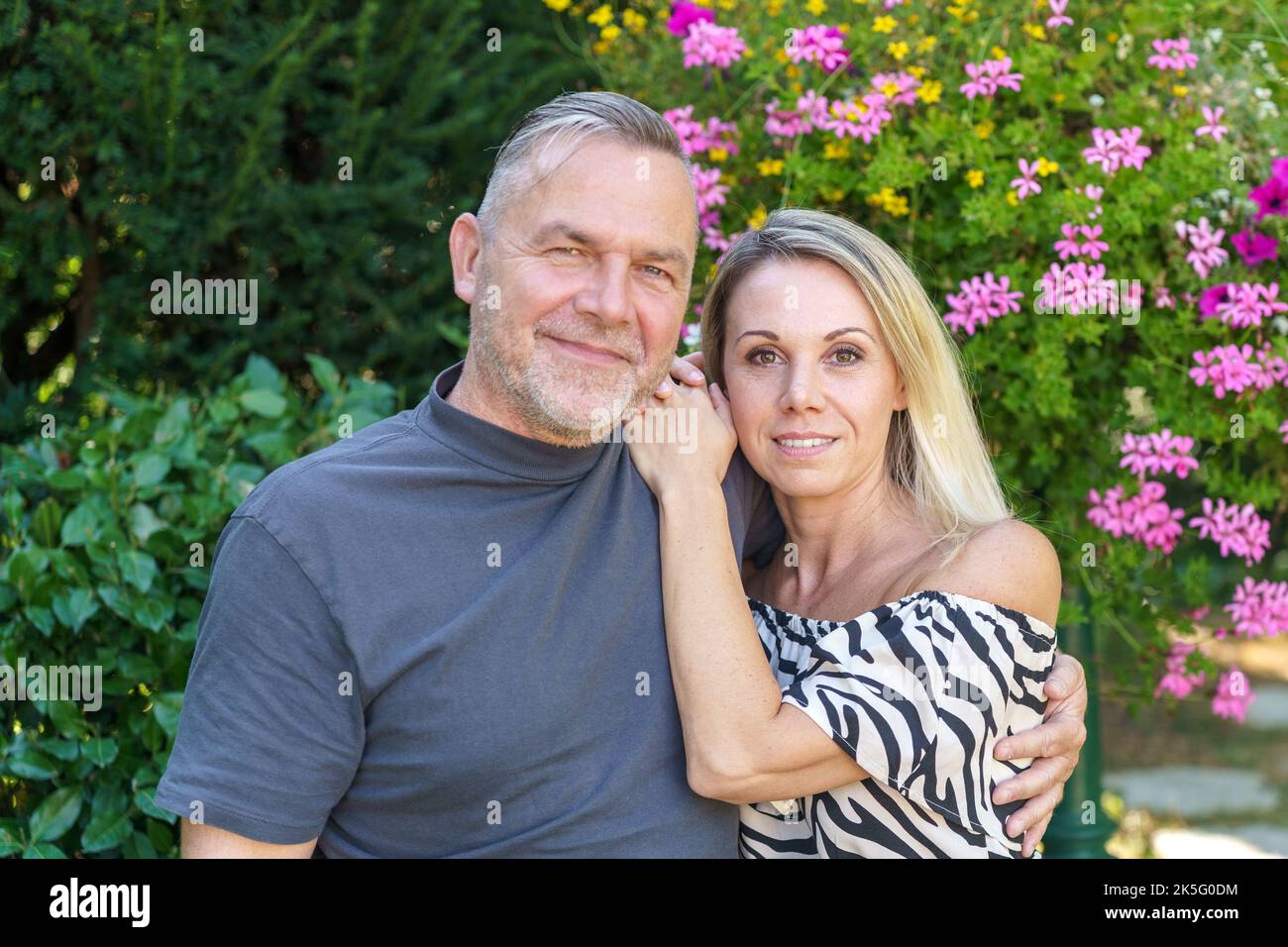 Happy middle aged couple posing arm in arm in a loving family portrait ...