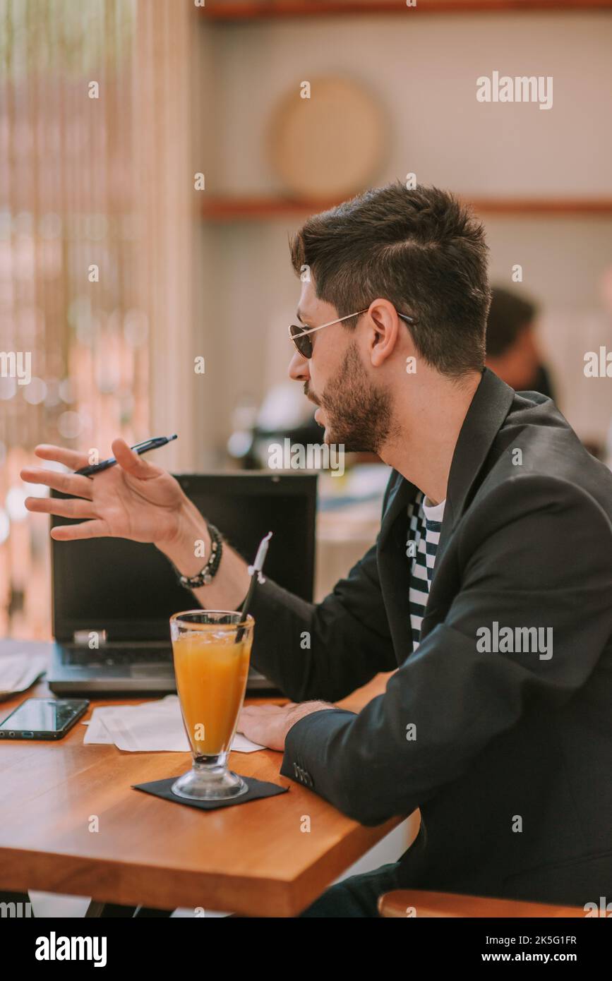 Handsome business man talking while sitting at the cafe Stock Photo - Alamy