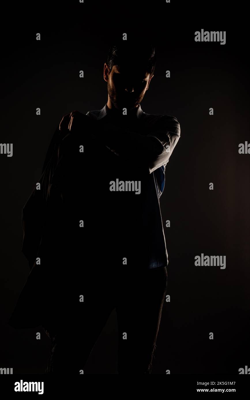 Attractive model taking off his jacket in the studio in front of the ...