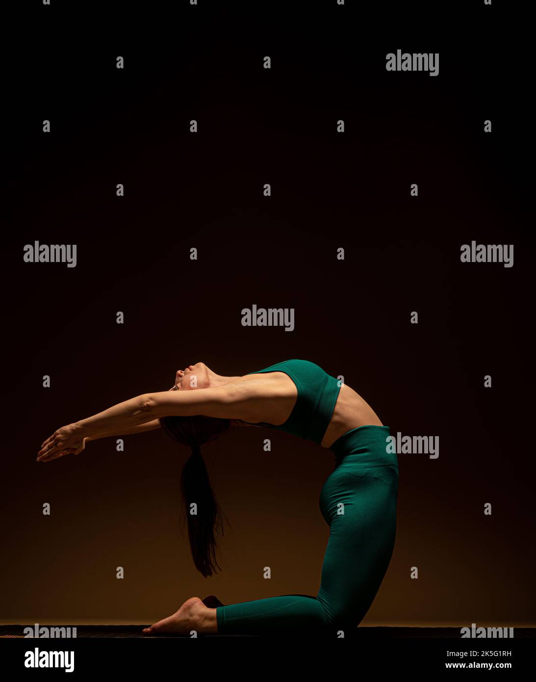 Attractive and beautiful young girl is stretching her back on the ...