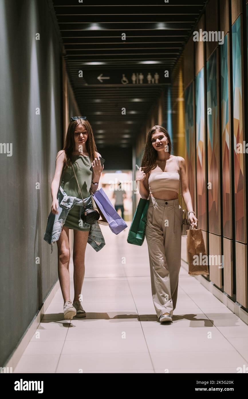 Two pretty girls walking in the hallway at the mall Stock Photo - Alamy