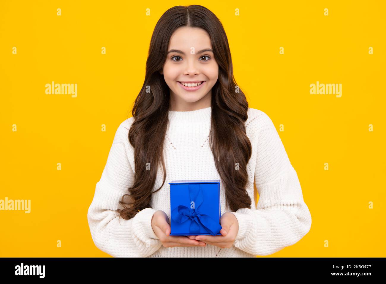 Child with gift present box on isolated studio background. Gifting for ...