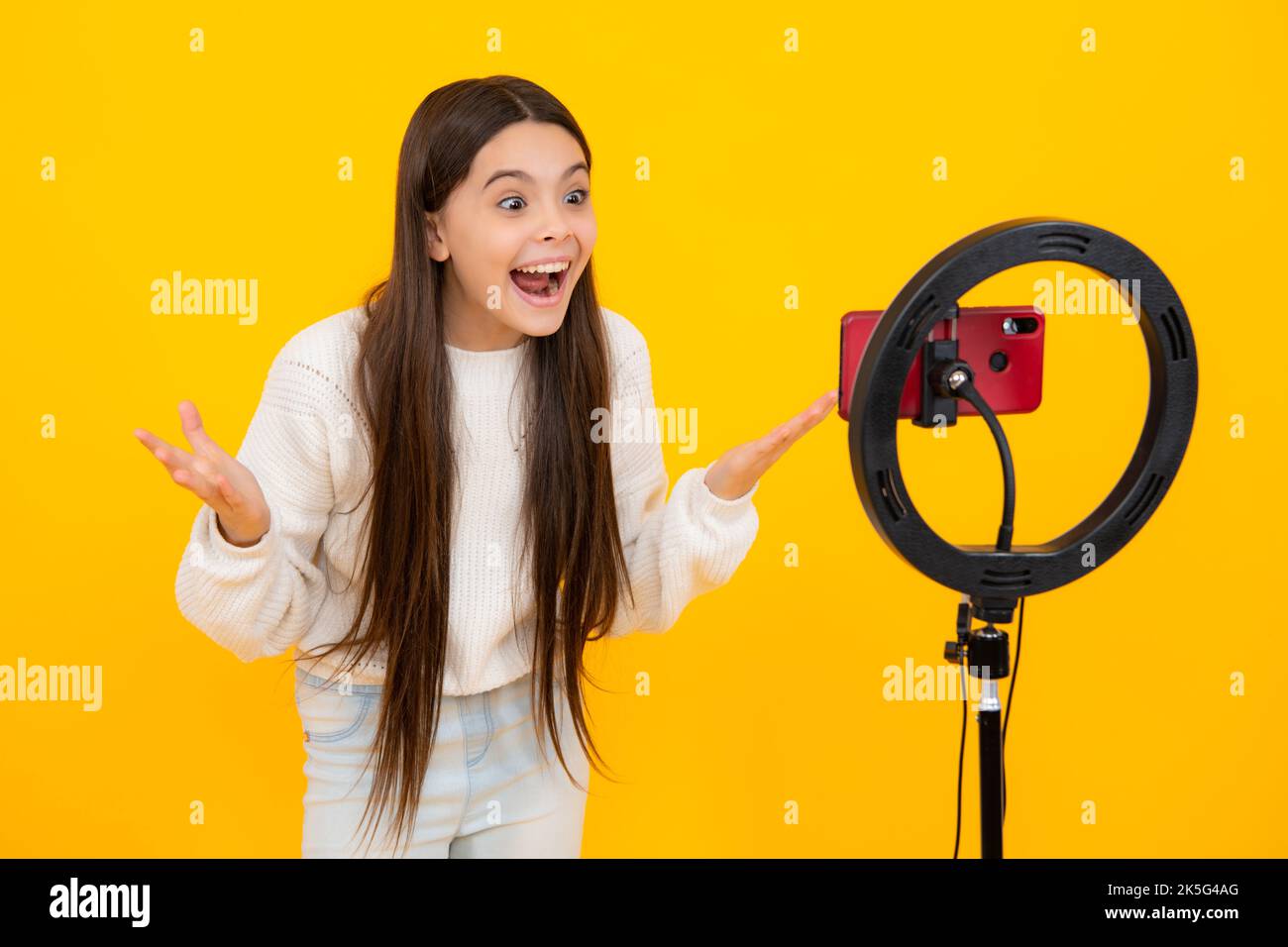 Teen girl blogger use selfie led lamp and smartphone on tripod for ...