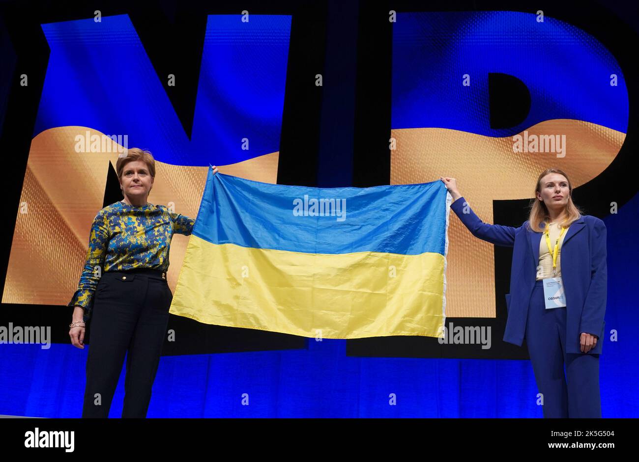 First Minister Nicola Sturgeon holds a Ukrainian flag on stage with ...