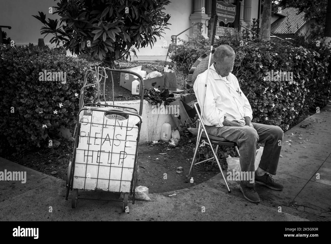 A grayscale shot of a blind man sitting in San Diego California Park ...