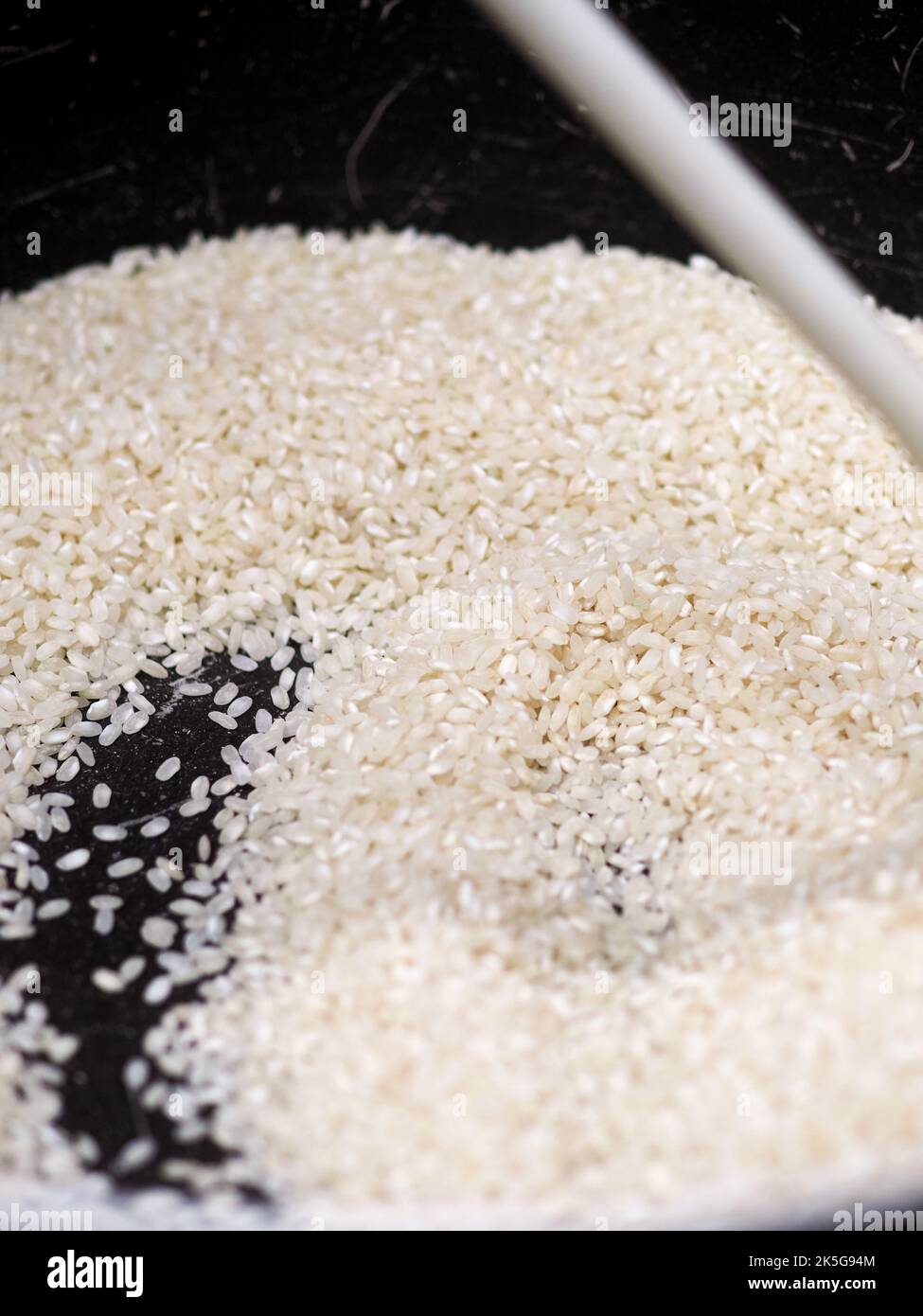 carnaroli rice grain mixing in the pan for risotto Stock Photo - Alamy