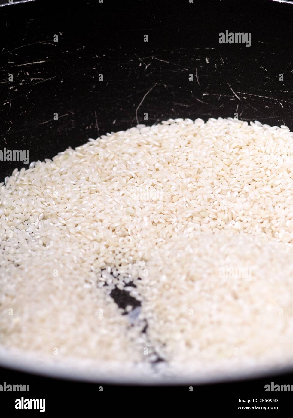 carnaroli rice grain mixing in the pan for risotto Stock Photo - Alamy