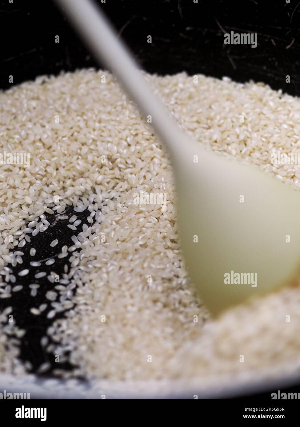 carnaroli rice grain mixing in the pan for risotto Stock Photo - Alamy