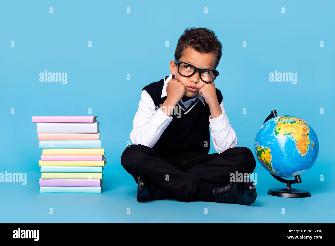 Full size portrait of minded intelligent boy sitting floor look empty ...