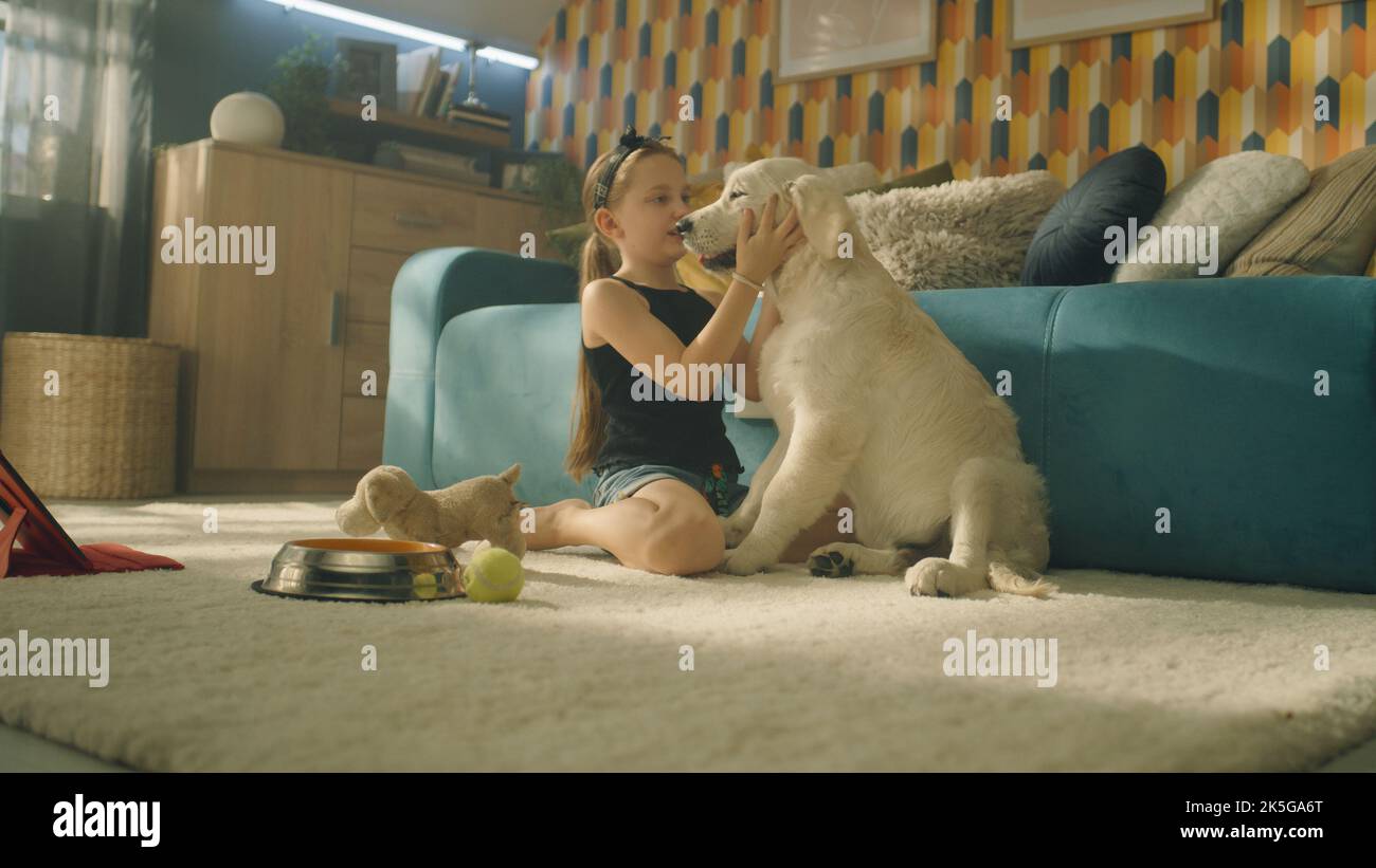 Young girl playing with dog, smiling and laughing, sitting together on ...