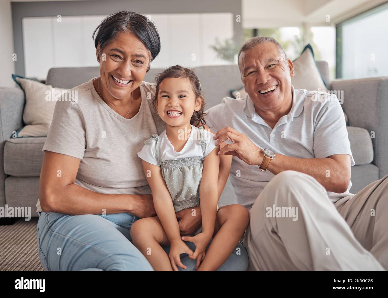 Grandparents, girl and floor in house, smile and playing while in ...