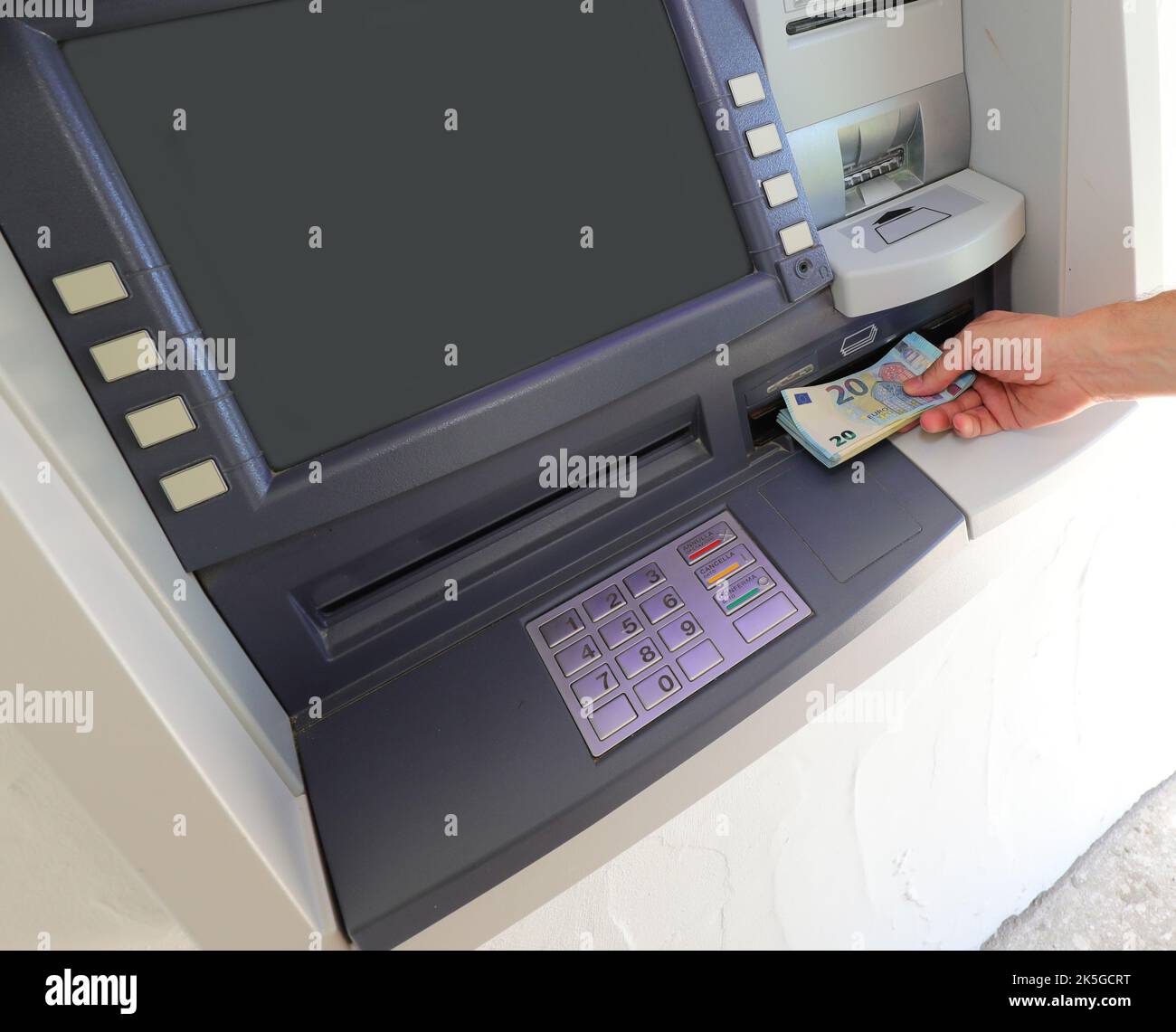 hand withdrawing money in european banknotes from an ATM bank machine ...