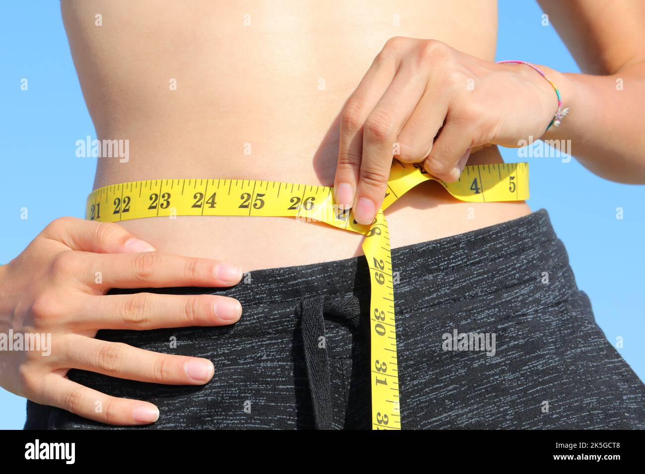 girl measures your waist with a yellow tape measure and measures in ...