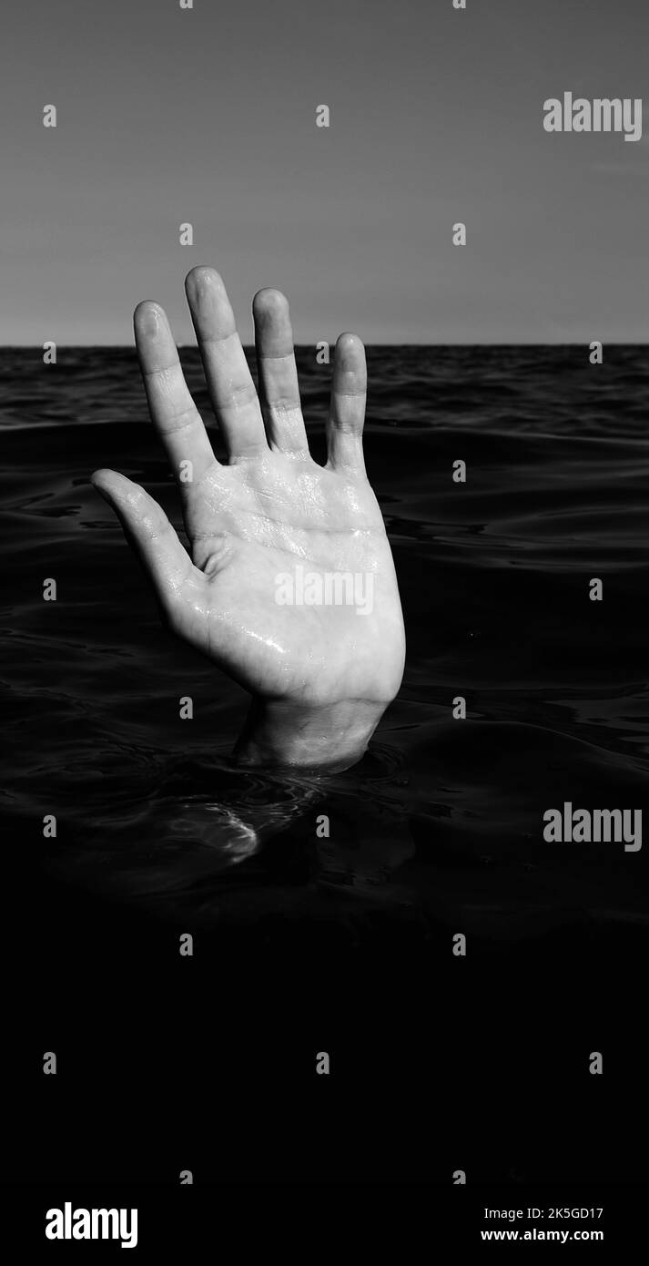 hand of the person with five fingers in the middle of the sea about to ...