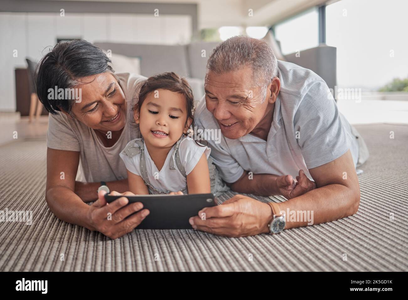 Relax, grandparents and cartoon on tablet with child on home floor ...