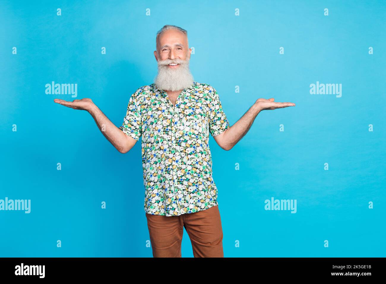 Photo of cheerful aged man arms palms hold empty space vs scales ...