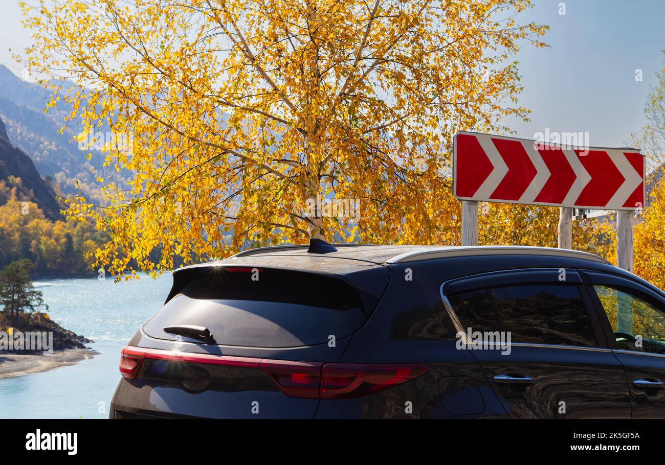 Side black car, parked in rest area next to red traffic sign: Turning ...