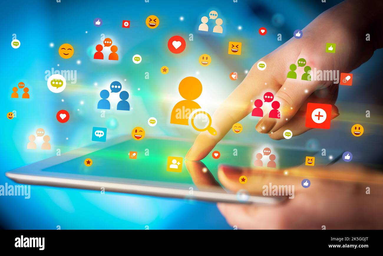 Close-up of a hand using tablet with social media icons Stock Photo - Alamy