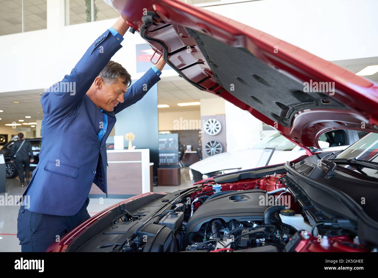 Man looks under the hood of a car with satisfaction Stock Photo - Alamy