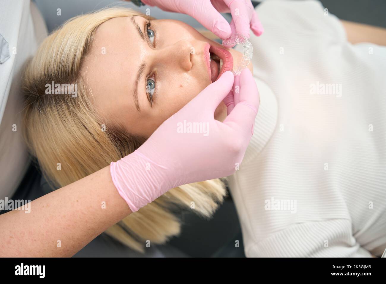 Doctor in pink gloves puts aligners on a patient Stock Photo - Alamy