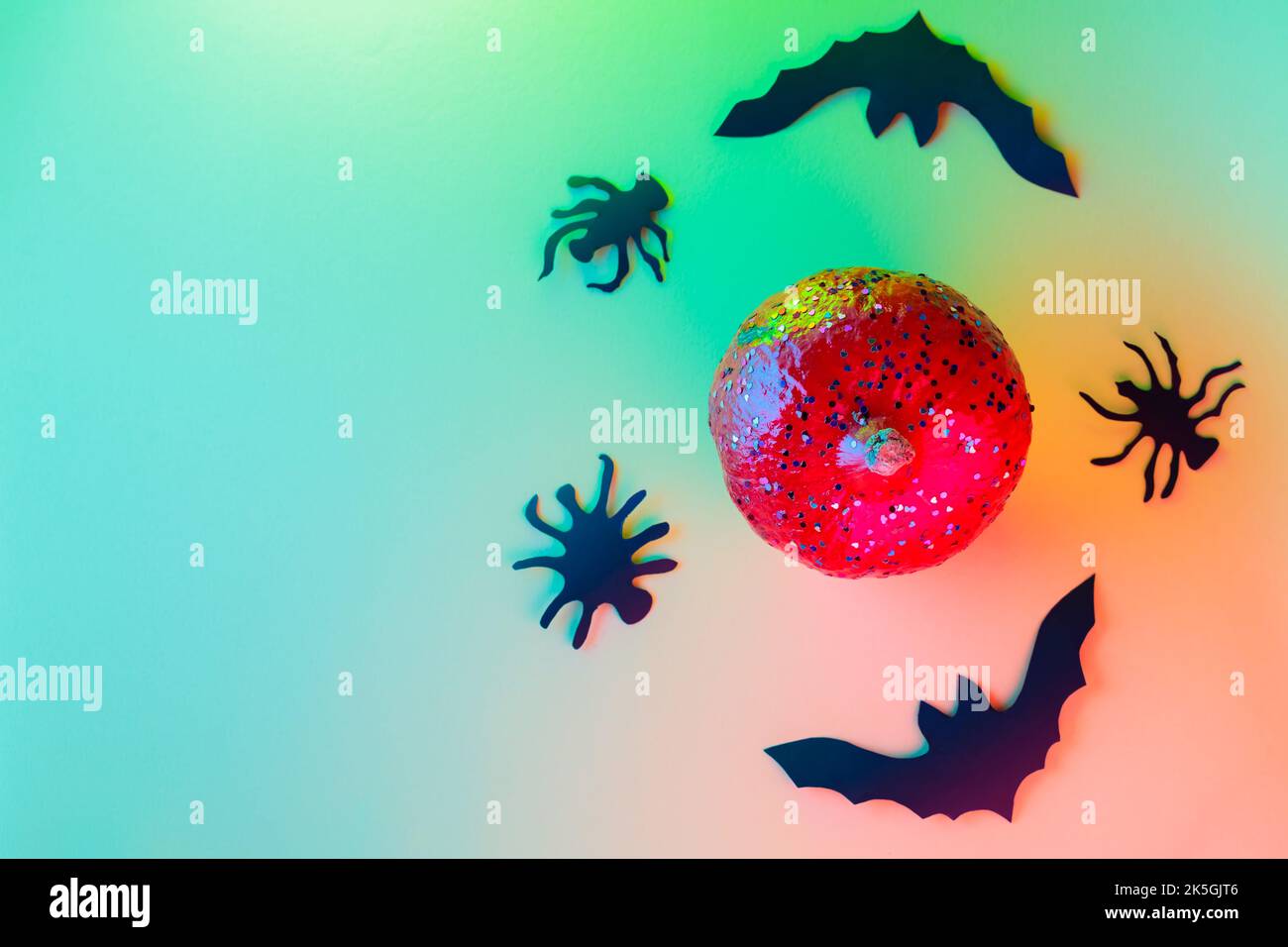 Glitter pumpkin and party decorations on colorful gradient background ...
