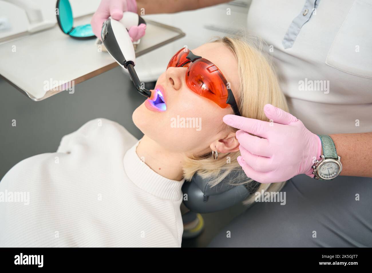 Doctor highlights the lamp to harden the seal Stock Photo - Alamy