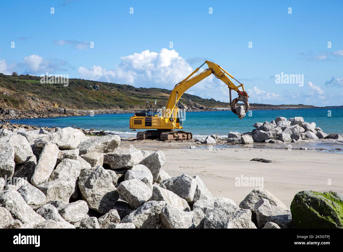 Mechanical diggers on a construction site repairing coast defences and ...