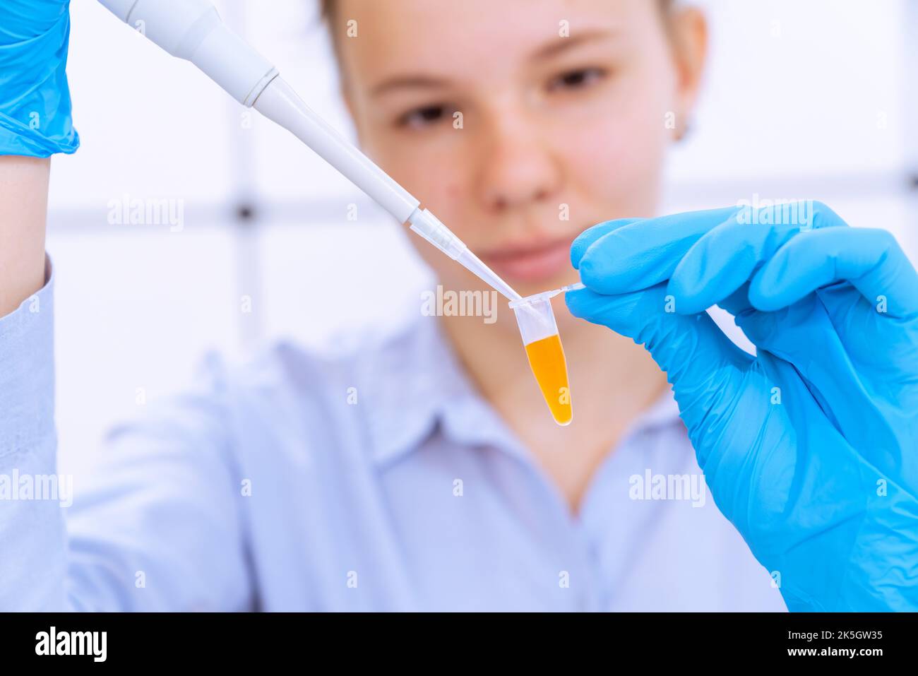 young woman fills a micro test tube with a dispenser Stock Photo - Alamy