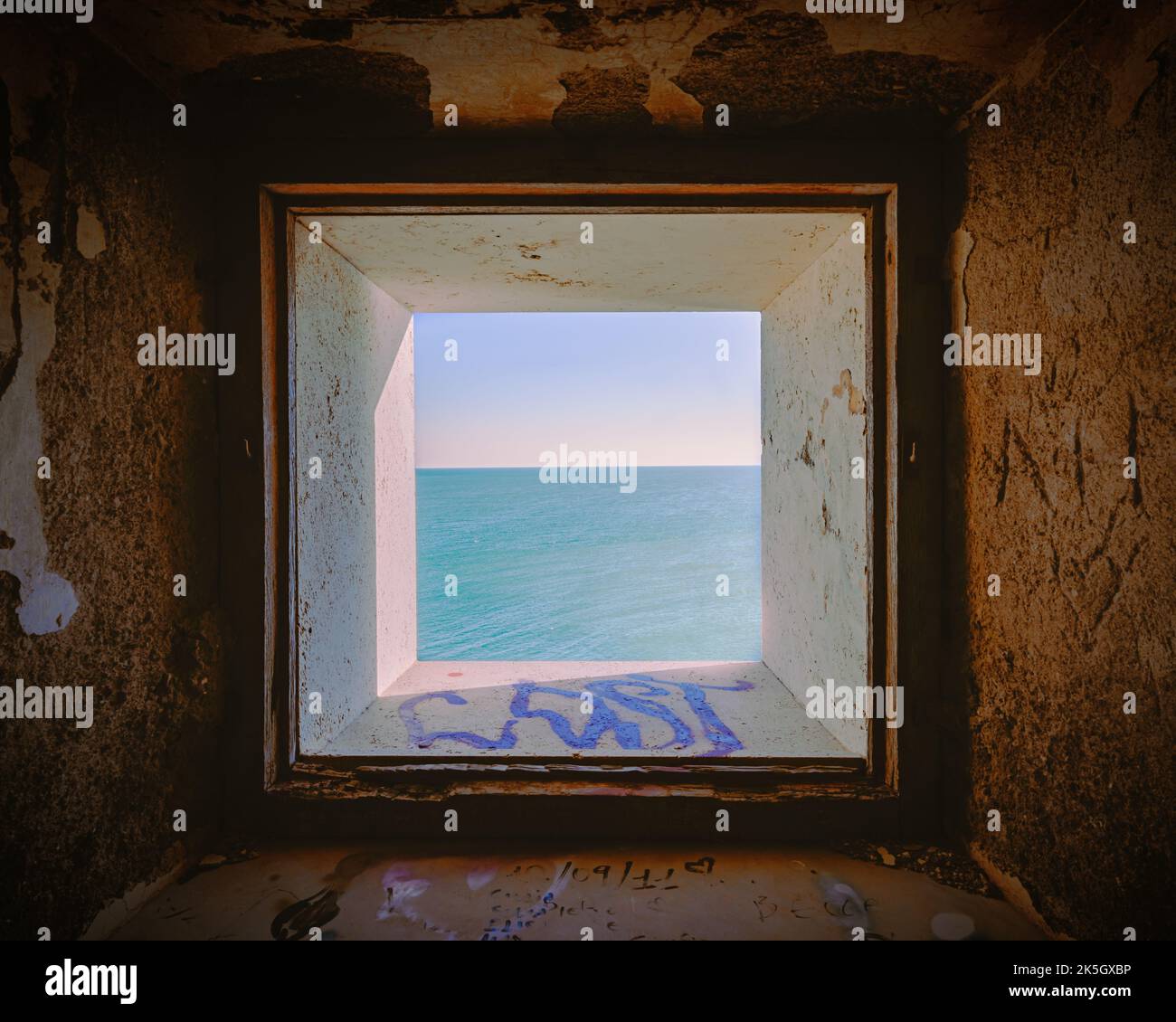 A scenic view through an old square window into the blue sea Stock ...