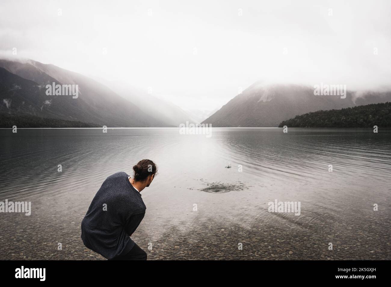 Boy throwing stone into water hi-res stock photography and images - Alamy