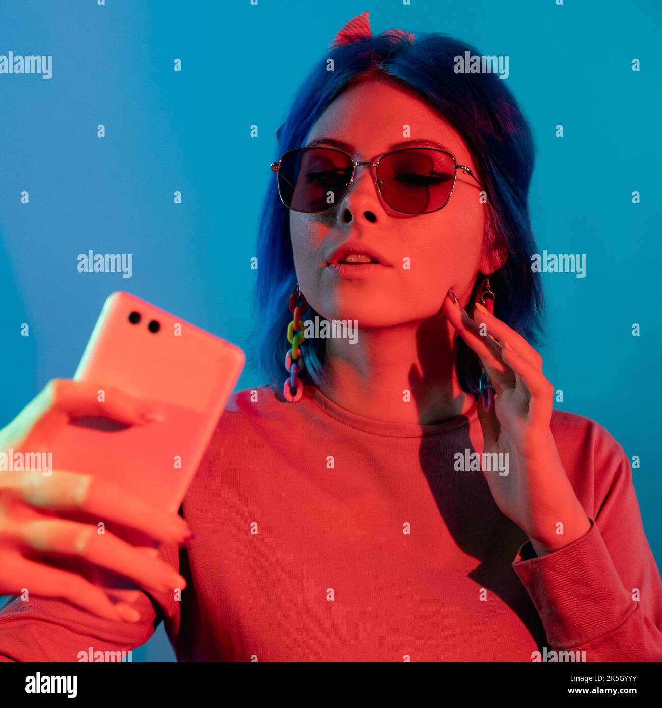 Neon light selfie. Futuristic technology. Digital people. Glamorous millennial woman taking ...