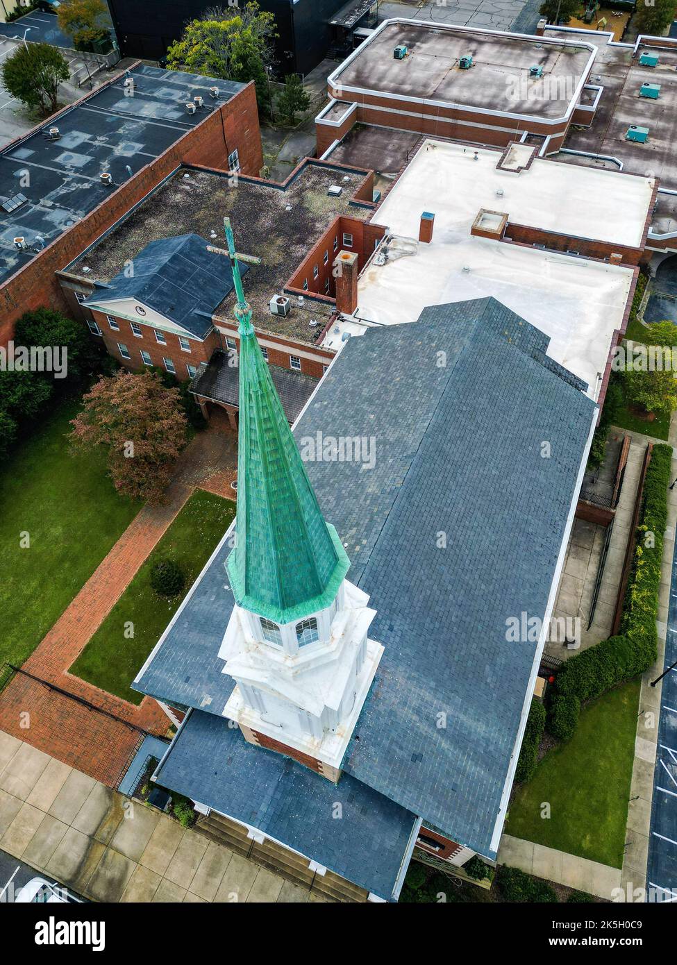 An aerial view of a green church steeple and roof with a cross Stock ...