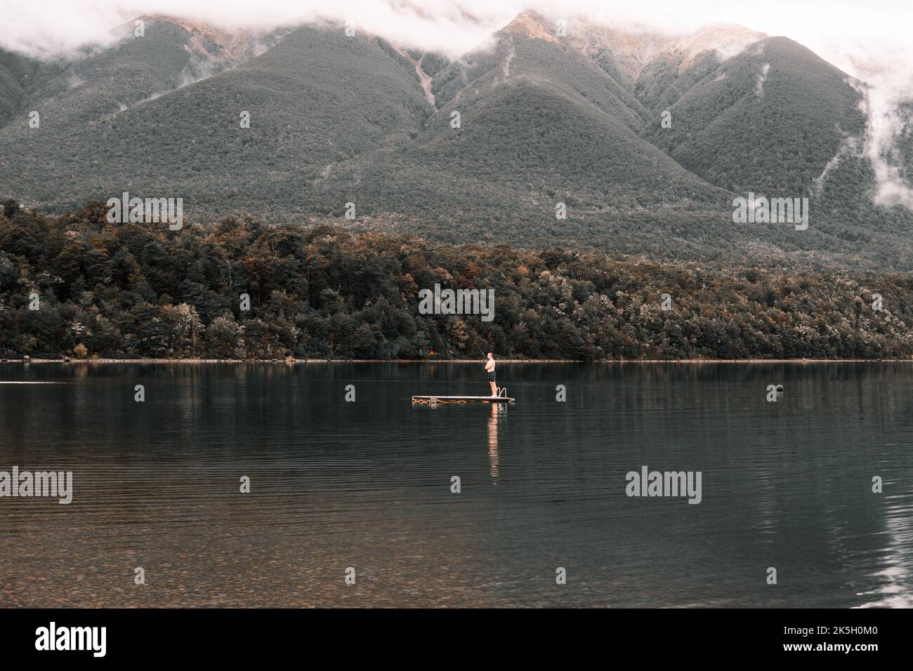 hairless caucasian young man in swimming trunks and on the wooden ...