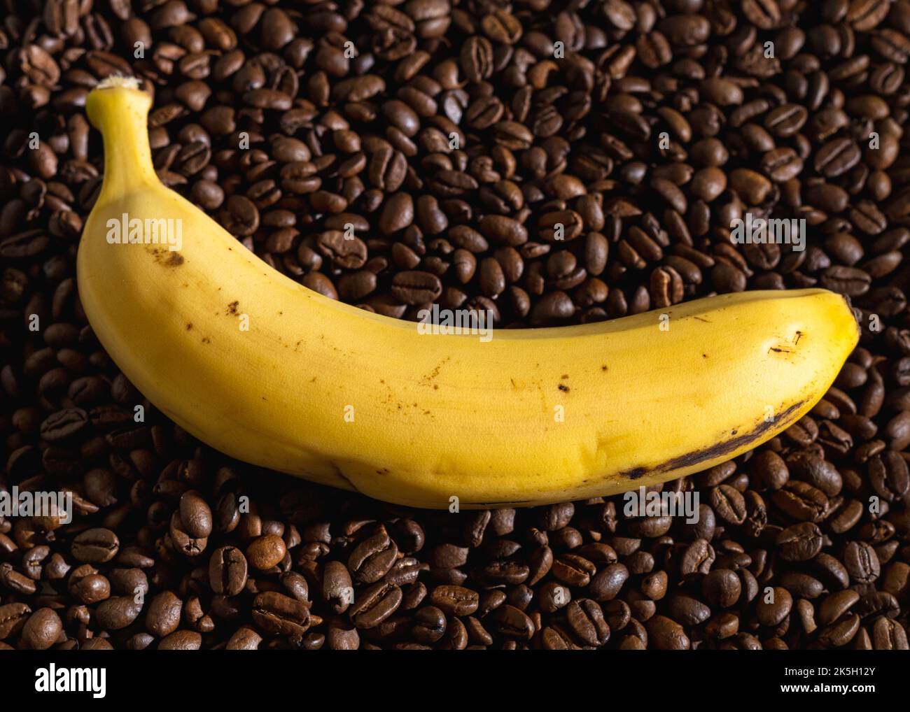 Banana on a background of coffee beans Stock Photo - Alamy