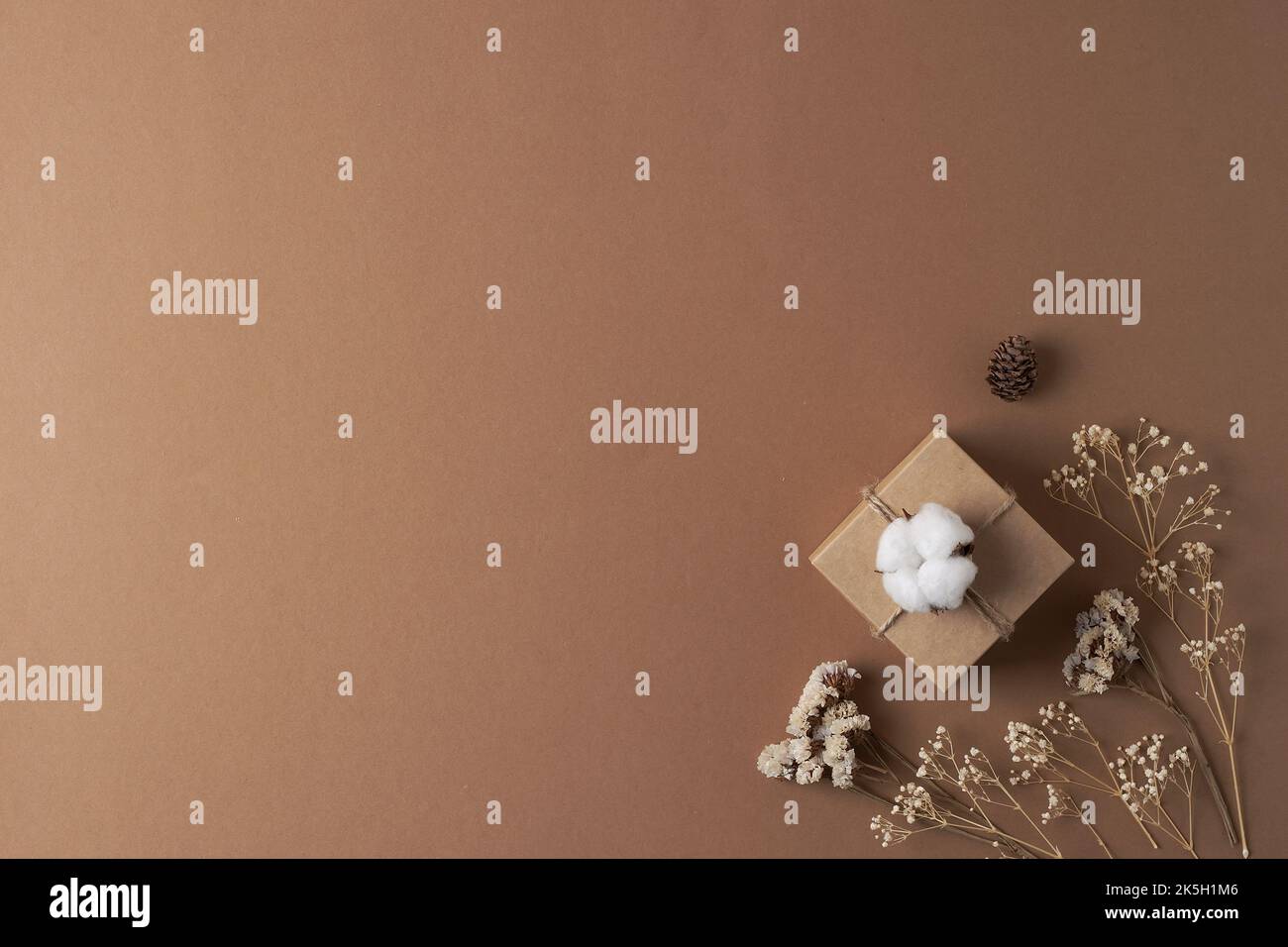 Christmas decorations with gift and flowers on brown background. Flat ...