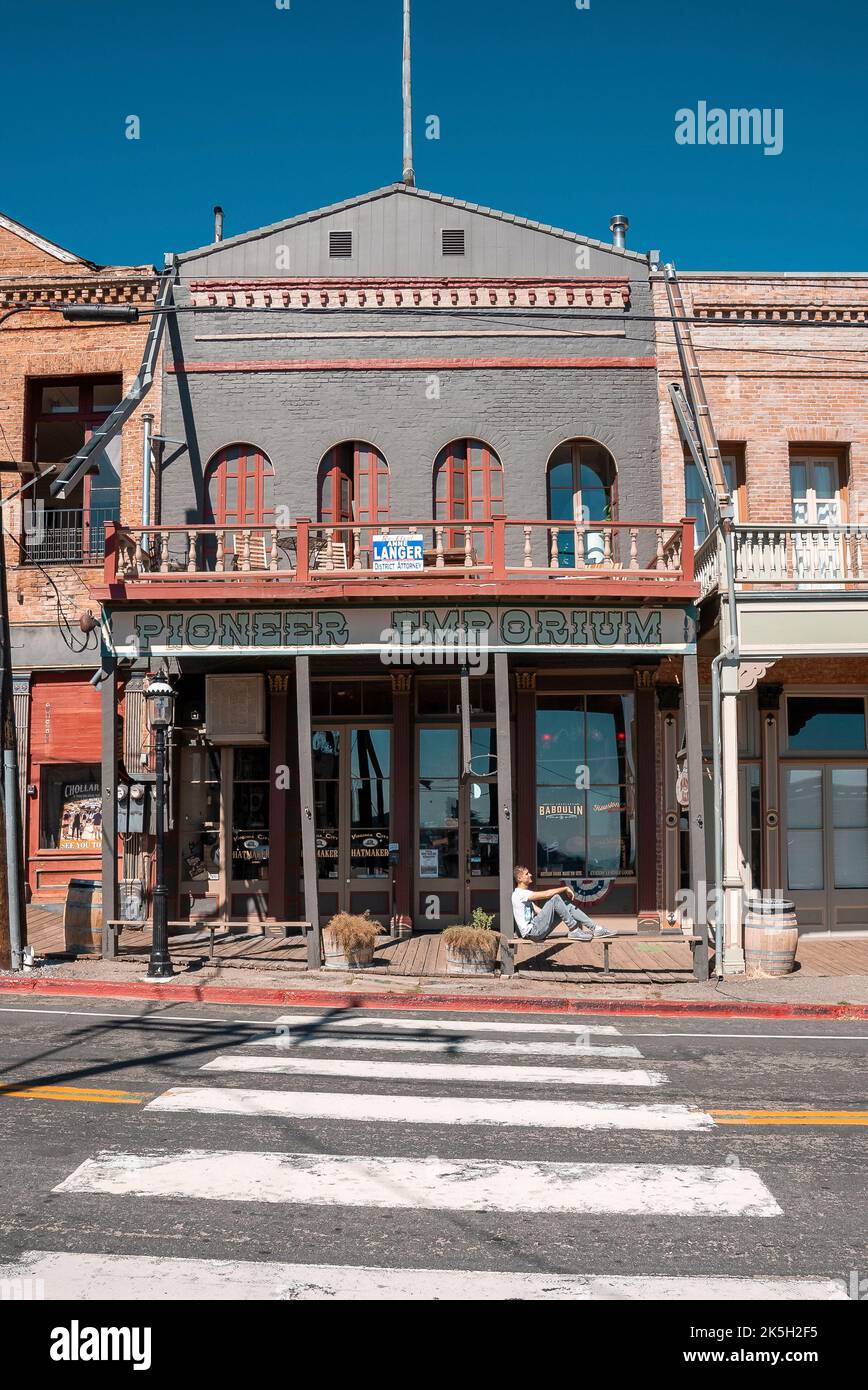 Tourist relaxing outside old Victorian style shop at vintage city ...