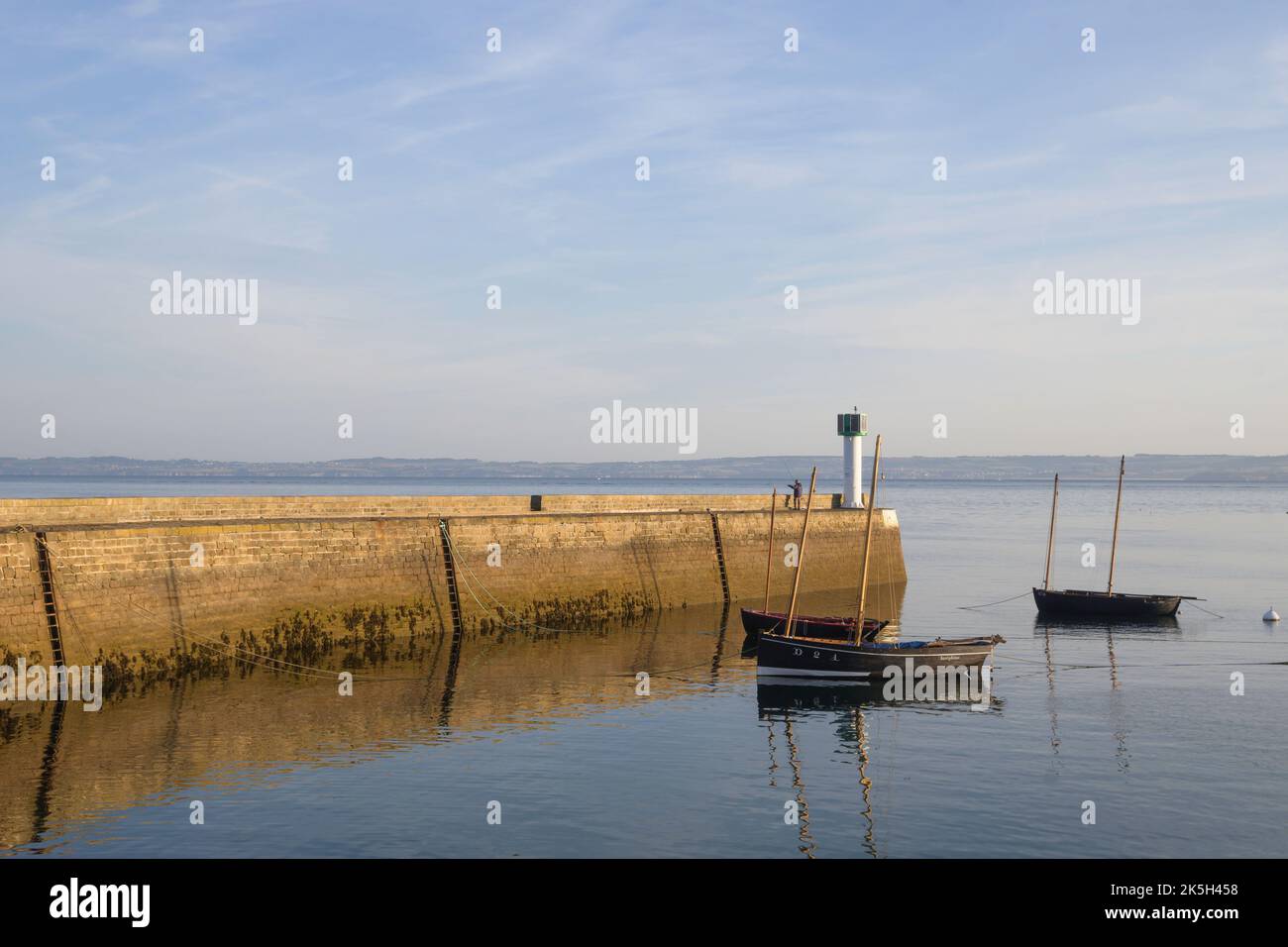 Old wooden boats moored at the pier entrance to Treboul harbour ...