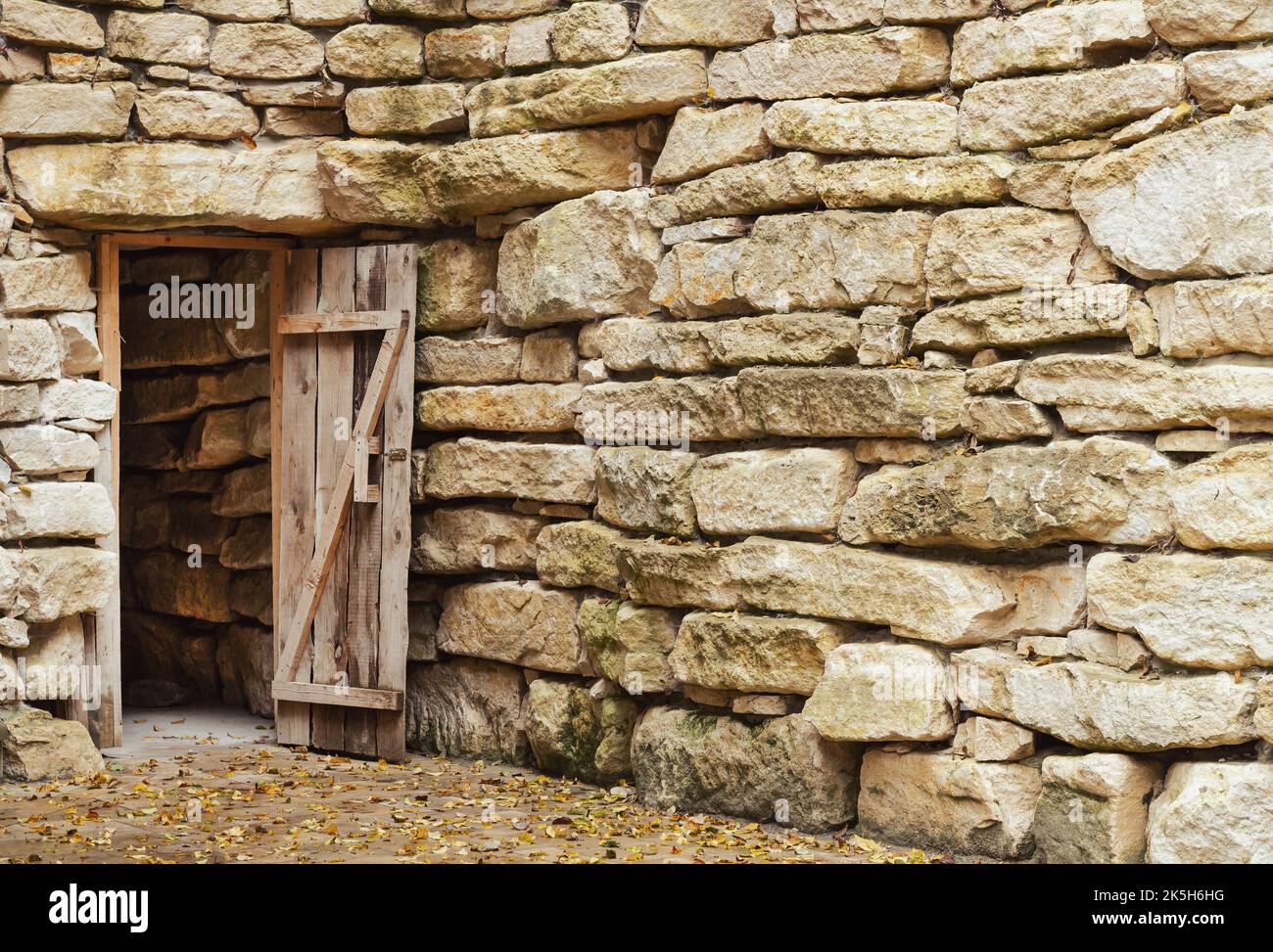 Open ancient wooden door in rough stone wall Stock Photo - Alamy