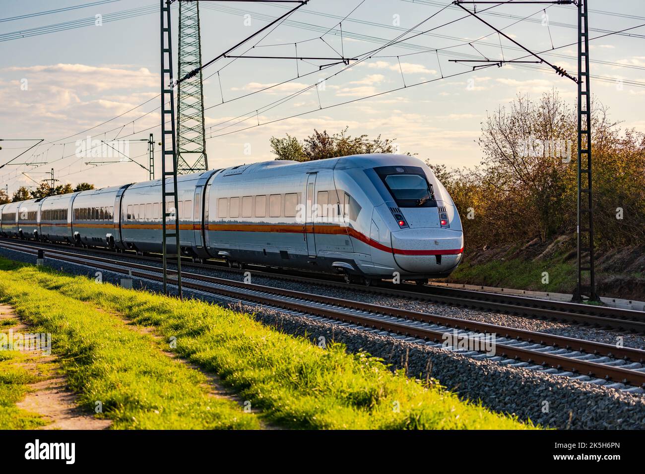 A modern InterCityExpress on a railway track in backlighting Stock ...